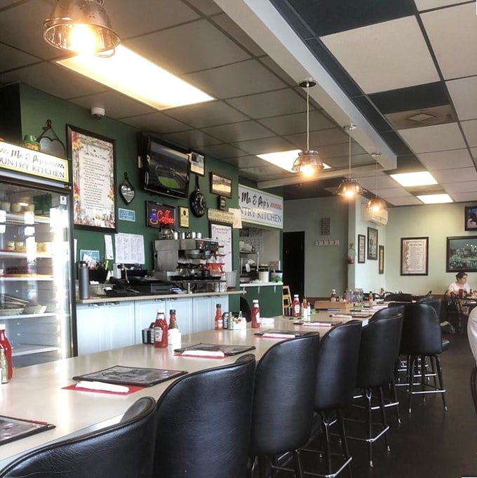 Counter seating puts you front-row for the breakfast show, where green walls and vintage decor create that perfect "been-here-forever" vibe.