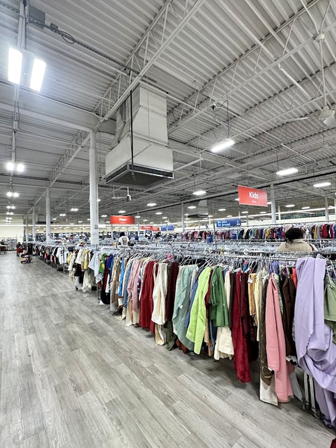 Endless racks stretch toward the horizon under industrial ceilings—this isn't shopping, it's an expedition with color-coded trail markers.