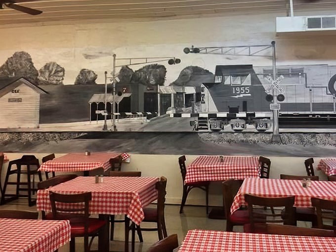 Red and white checkered tablecloths set against a historic train mural – dining here is like stepping into a Norman Rockwell painting of Southern life.