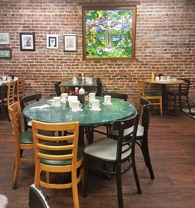 Exposed brick walls and mismatched chairs create the perfect backdrop for breakfast epiphanies. That stained glass adds a touch of unexpected elegance.
