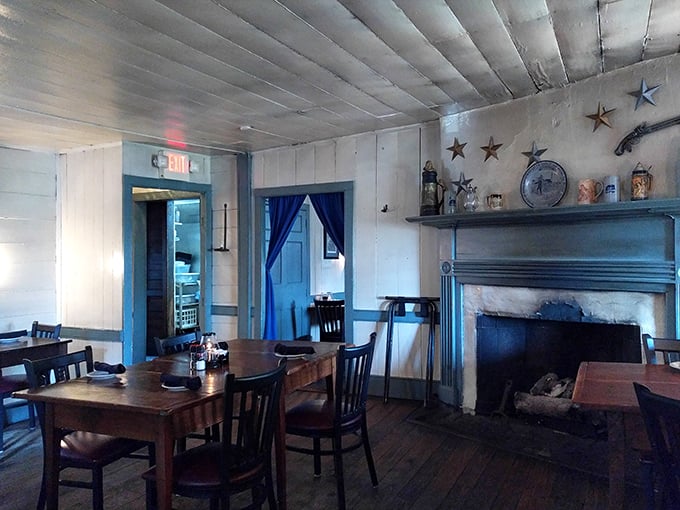 Blue trim and exposed beams frame a dining room where George Washington could walk in and feel right at home. The fireplace isn't just decorative—it's been warming diners for centuries.