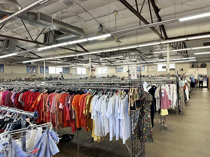 Clothing racks stretch toward infinity, a textile galaxy where fashion treasures orbit just waiting to be discovered.
