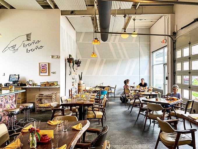 Industrial chic meets comfort at Milktooth's interior, where garage doors frame natural light and mismatched chairs invite you to settle in for something extraordinary.
