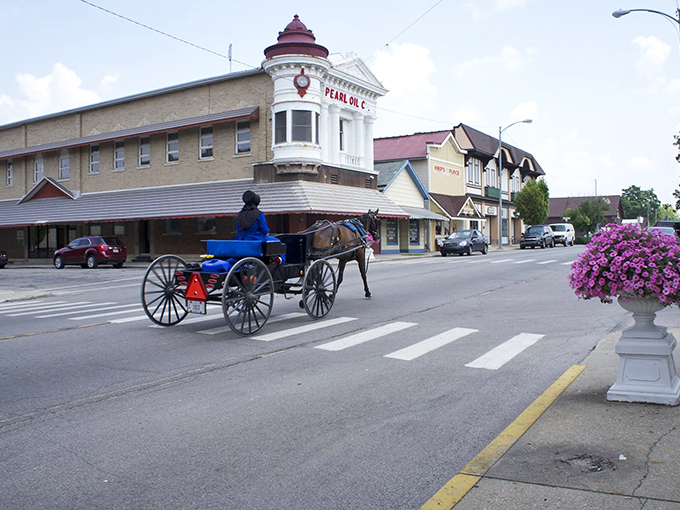 Downtown Berne's historic charm shines as a horse-drawn carriage passes the Pearl Oil building—Switzerland meets Indiana in perfect harmony.