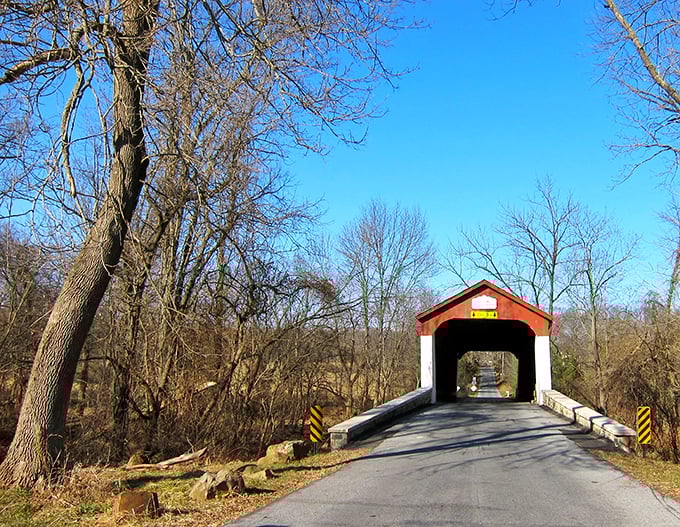 This red covered bridge isn't just crossing water—it's crossing time. Driving through feels like starring in your own historical movie.
