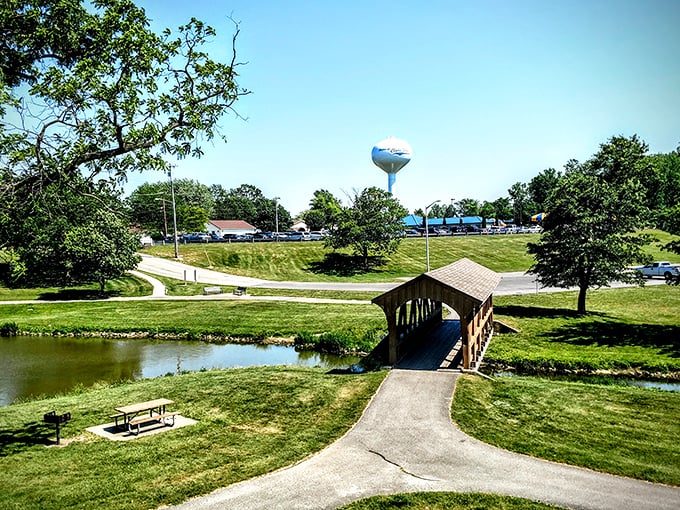 Community Park's covered bridge creates a scene straight from a retirement brochure—peaceful water, green spaces, and that iconic water tower watching over it all.