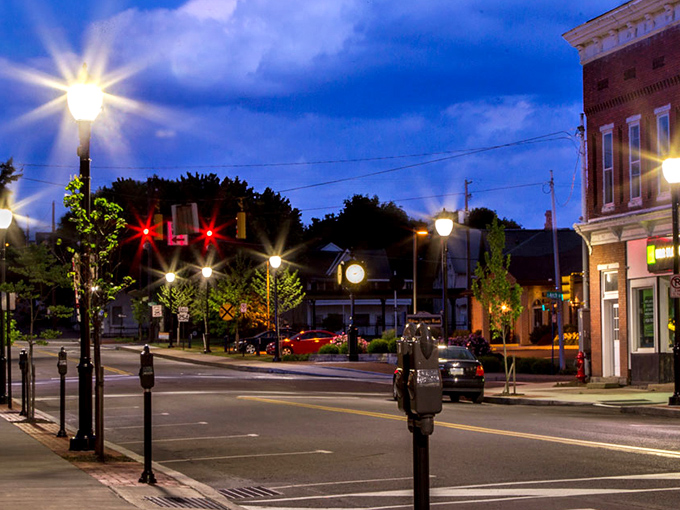 As twilight falls, Milton's vintage lampposts cast a warm glow on streets that feel like a time capsule—minus the dial-up internet and shoulder pads.