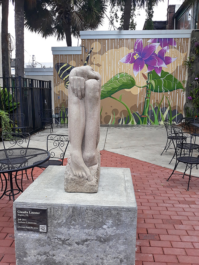 Art and nature coexist beautifully in this courtyard, where a stone sculpture stands guard while a vibrant mural reminds us that Florida isn't just about beaches.