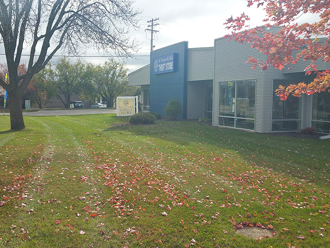 Even in autumn's embrace, the distinctive blue façade stands out like a sapphire among fallen leaves, quietly promising treasures inside.