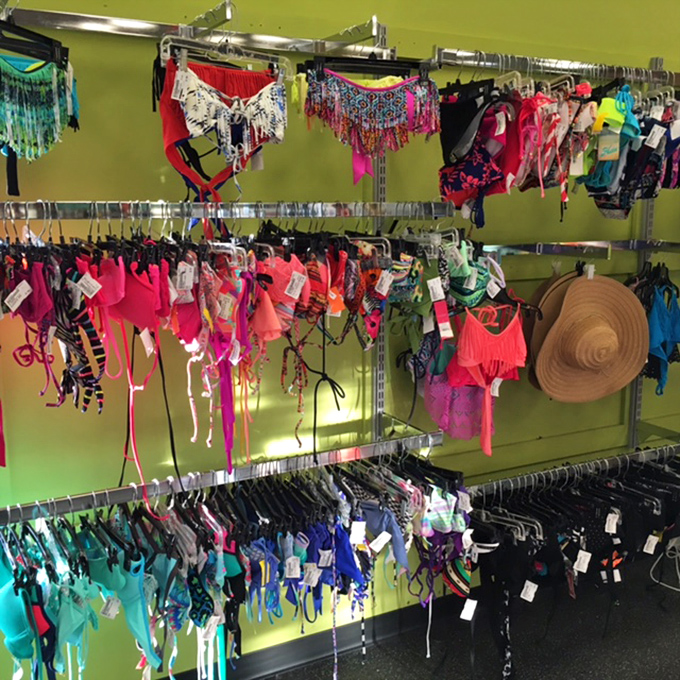 Beach season never breaks the bank here. Vibrant swimwear in every hue imaginable hangs against that signature lime green wall.
