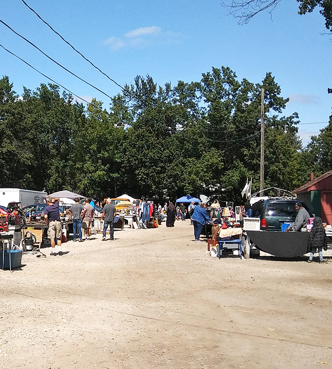 Main Street, flea market edition—where shoppers stroll gravel pathways between tables laden with possibilities and vendors ready with stories behind every item.