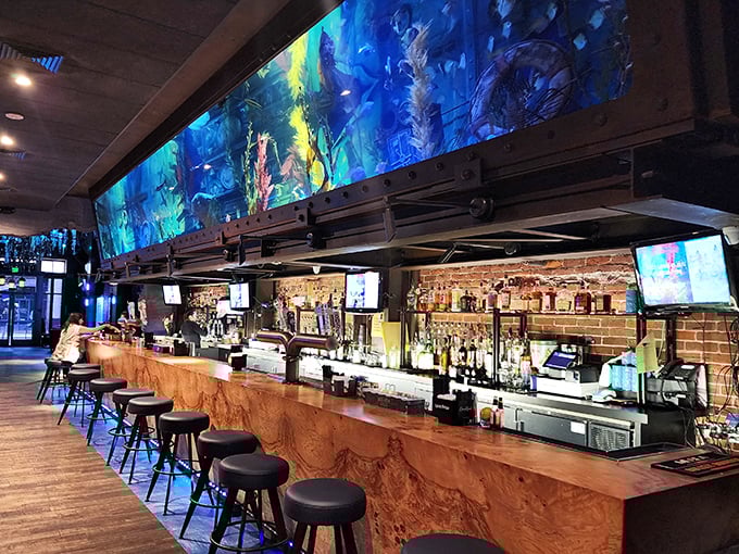 Not your average watering hole – Dive Bar's expansive aquarium hovers above patrons like a blue-hued halo of liquid magic.