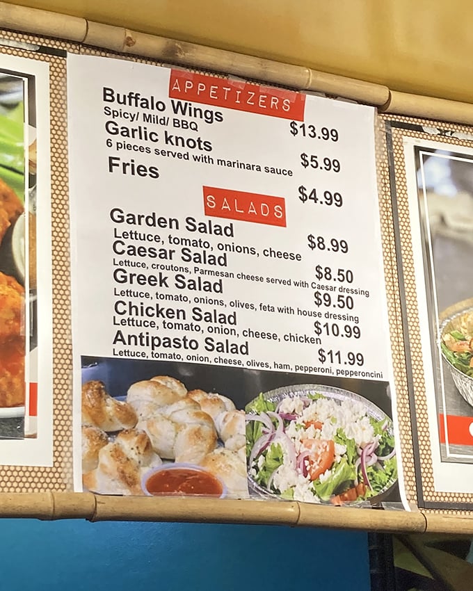 The menu board tells a story of Italian-American classics. Buffalo wings, garlic knots, and Greek salads set the stage for the main event.