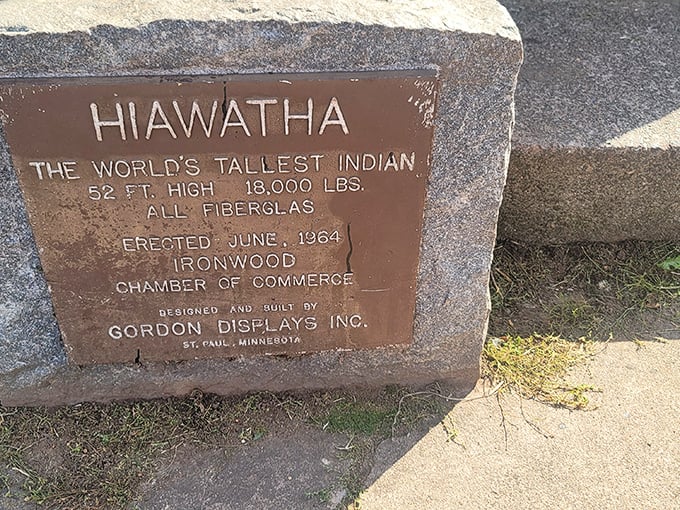 History cast in bronze: The plaque confirms what your neck already knows—this is indeed the "World's Tallest Indian" at a staggering 52 feet.