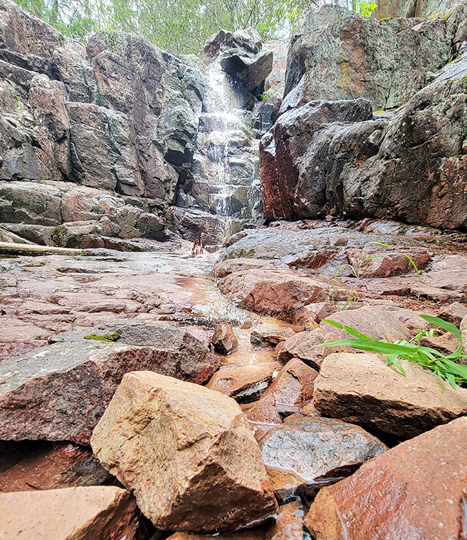 Water tumbles dramatically between towering rock walls, creating a natural cathedral where geology and hydrology perform their daily symphony.