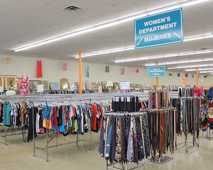 The women's department stretches toward the horizon like a fashionista's dream. Racks organized by color create a rainbow road of secondhand style possibilities.