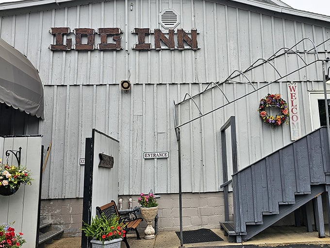 Around back, the rustic charm of The Log Inn continues. That "Welcome" wreath isn't just decoration—it's a promise of the hospitality waiting inside.