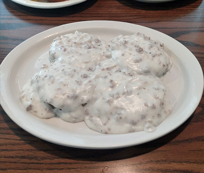 Biscuits drowning in gravy like fluffy clouds in a delicious thunderstorm – this is how mornings were meant to begin.
