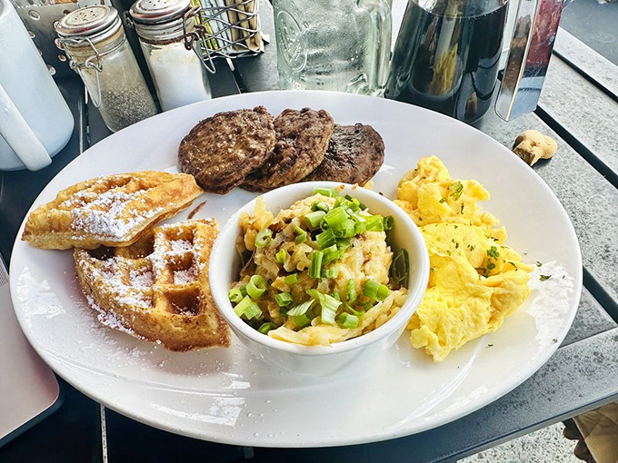 Breakfast's greatest hits on one plate: golden waffles, savory sausage patties, creamy mac and cheese, and eggs that practically pose for their close-up.