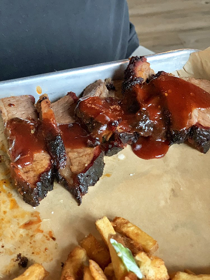 Behold the brisket in all its glory—that bark, that smoke ring, that sauce. This isn't food; it's edible poetry.