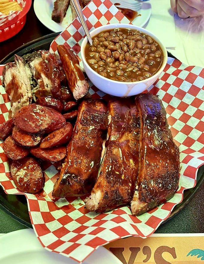 These glistening ribs with a side of baked beans aren't just food—they're edible proof that patience and smoke create magic.