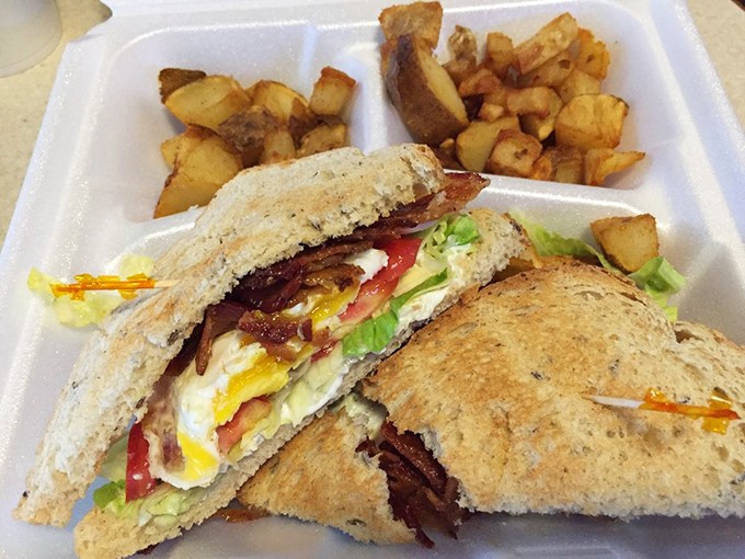 Breakfast perfection doesn't need fancy plating. This hearty sandwich stacked with bacon, egg and fresh veggies alongside golden home fries proves simple is sublime.