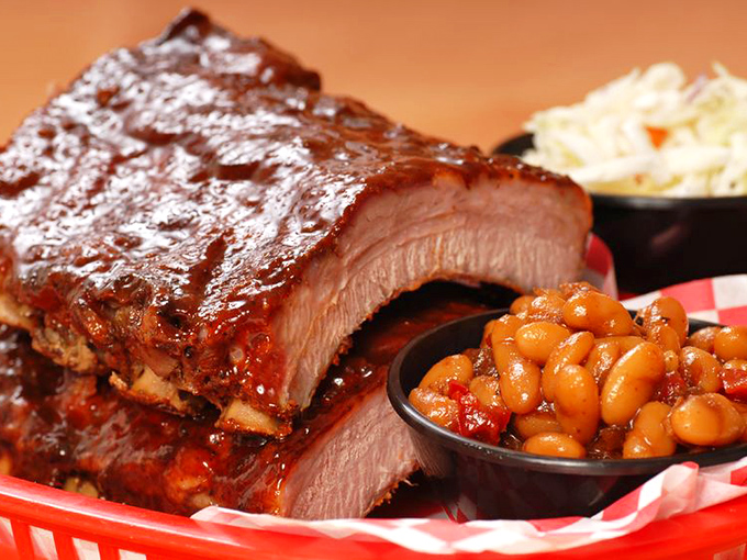 Glistening with sauce and sporting that perfect pink smoke ring, these ribs aren't just food – they're edible artwork with a side of beans.