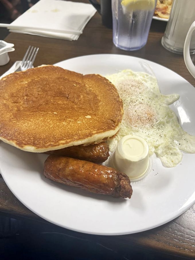 Breakfast nirvana on a plate: a golden pancake, perfectly cooked eggs, and sausage links that would make even the most dedicated health nut temporarily abandon their principles.