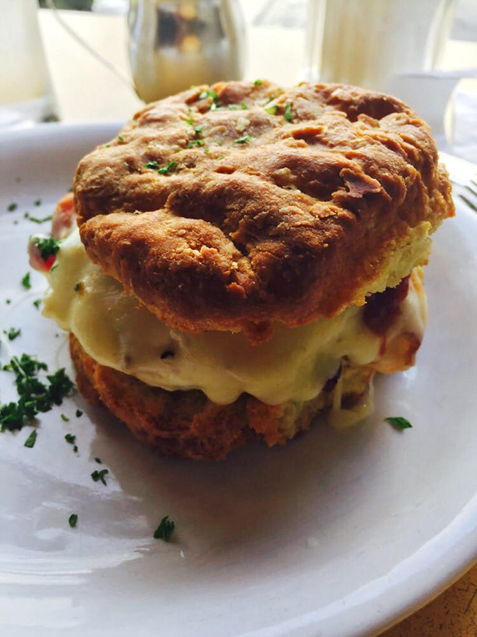 This isn't just a biscuit sandwich—it's a masterpiece of flaky, buttery architecture holding together what might be the world's perfect breakfast.