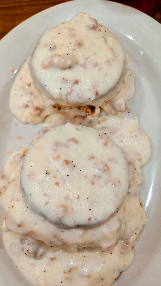 Biscuits swimming in creamy, peppery gravy—a Southern baptism that transforms ordinary mornings into religious experiences. Calories? What calories?