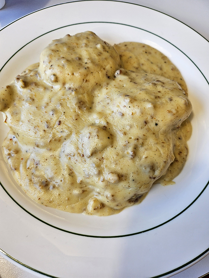 Behold the star attraction: biscuits drowning happily in a sea of peppery sausage gravy. Napkins required, regrets impossible.