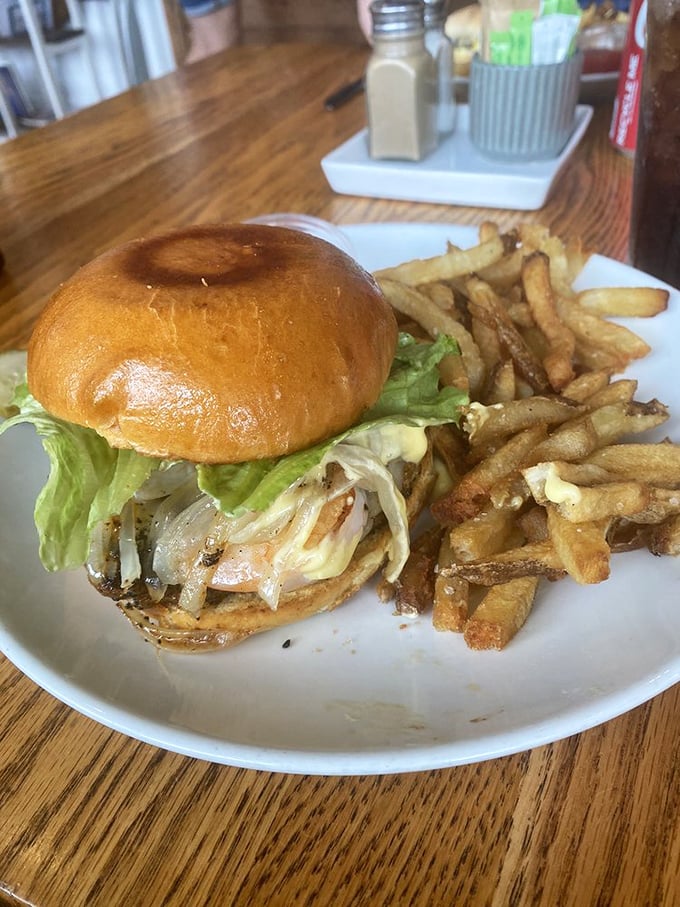This isn't just any burger—it's a revelation on a bun. Golden fries stand at attention beside their more famous companion, ready for their supporting role.