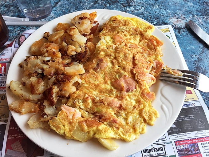 Breakfast perfection on a plate—a ham and cheese omelet that's seen the inside of a properly hot pan, with home fries crisped to golden glory.