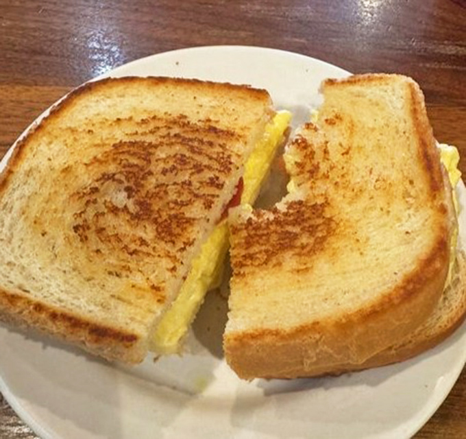 Golden-brown toast embracing fluffy eggs and melted cheese—this breakfast sandwich isn't just good, it's the reason alarm clocks were invented.