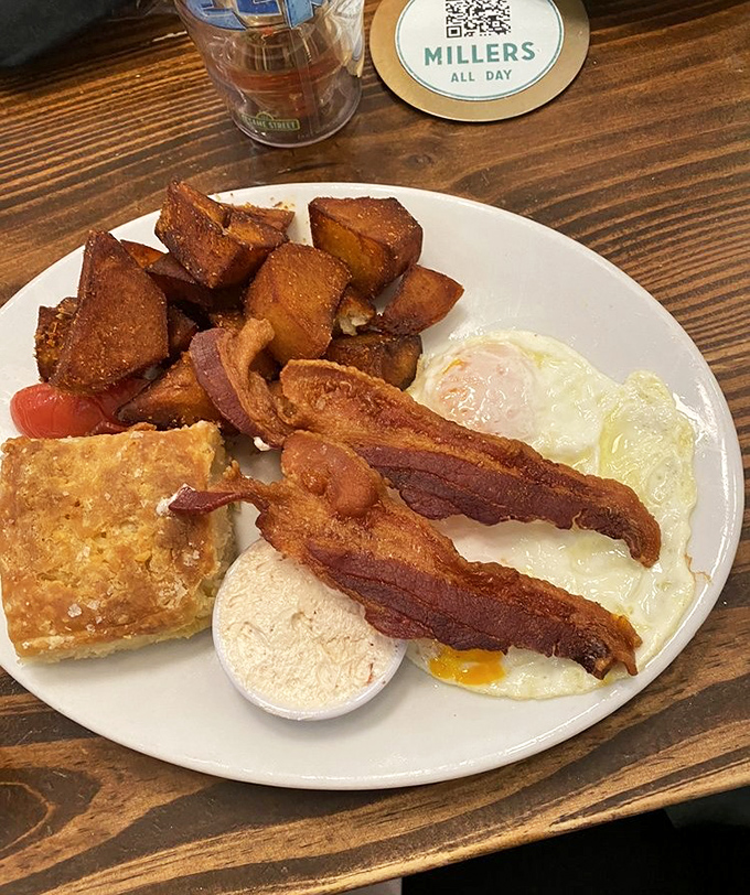 Breakfast perfection on a plate: crispy home fries, perfectly cooked eggs, and bacon that makes you question why we ever invented lunch.