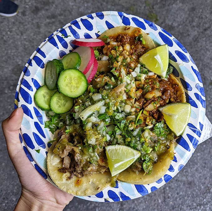A blue plate special that's actually special—tacos adorned with fresh cilantro, onion, and lime wedges that make every bite a celebration.