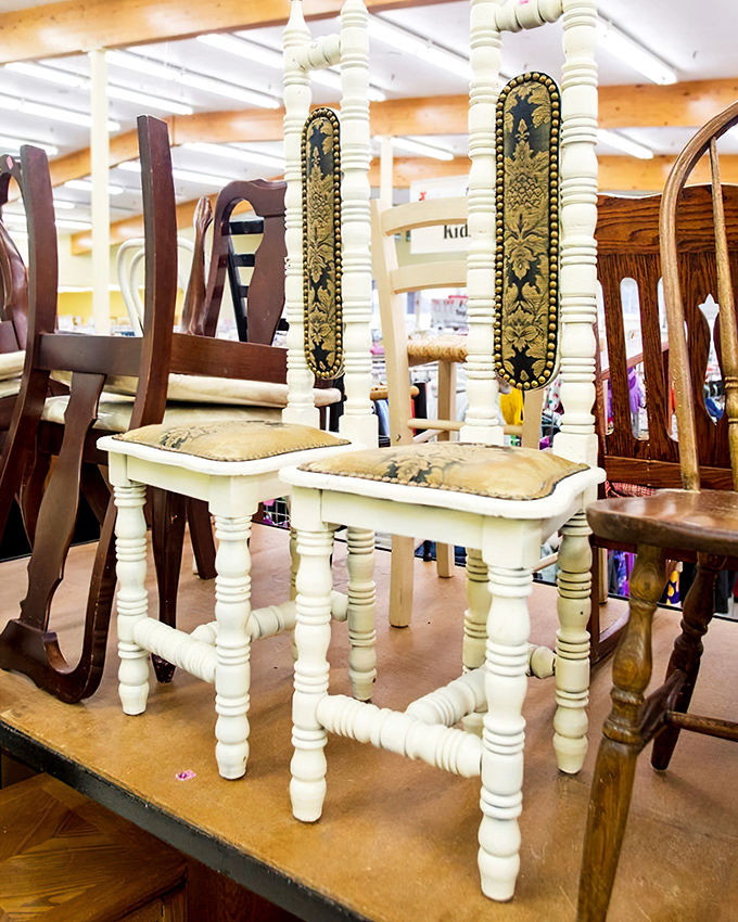 These aren't just chairs—they're time machines with cushions. That ornate white pair looks like it hosted tea with Victorian royalty in a previous life.