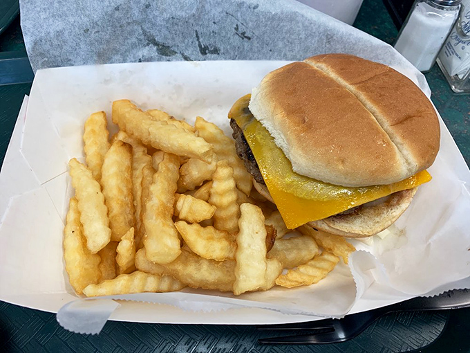 The classic cheeseburger and crinkle-cut fries—a duo more iconic than Batman and Robin. Simple perfection served on paper, as the food gods intended.