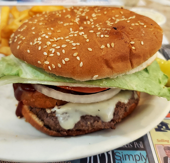 Behold the cheeseburger in its natural habitat: perfectly melted cheese cascading down a hand-formed patty on a sesame-studded throne.