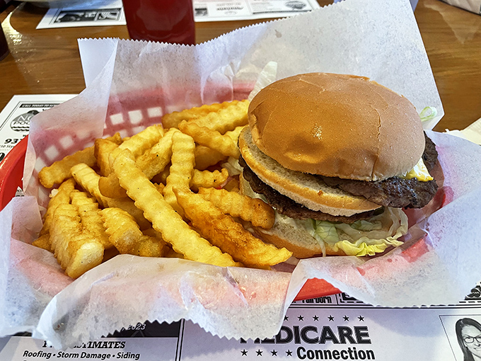 Behold the star of the show! Golden crinkle-cut fries flanking a burger that doesn't need Instagram filters to look mouthwatering.