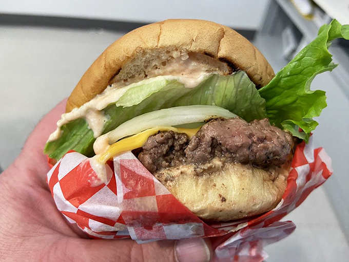 The classic cheeseburger in its natural habitat—wrapped in checkered paper and stuffed with fresh ingredients. Simplicity that sings.