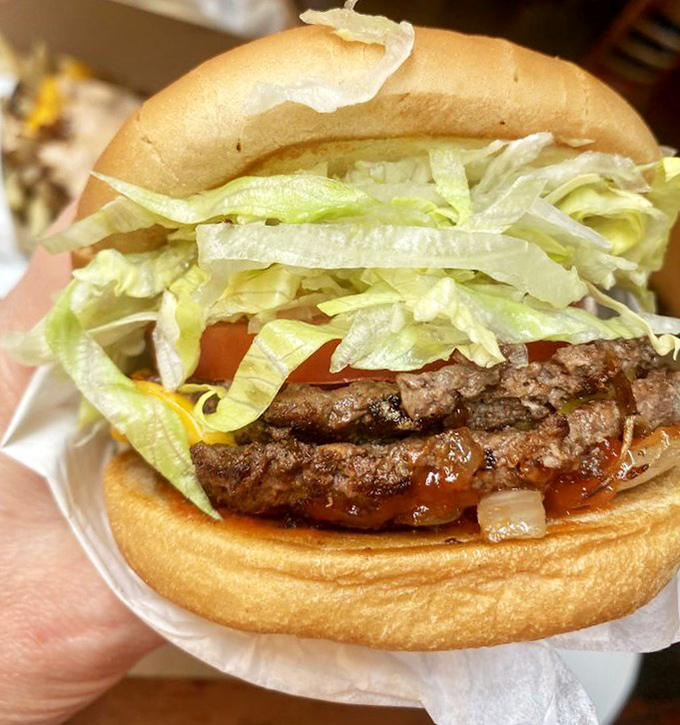 This isn't just a burger; it's edible architecture – a perfect stack of beef, cheese, and fresh toppings that makes your mouth water before the first bite.