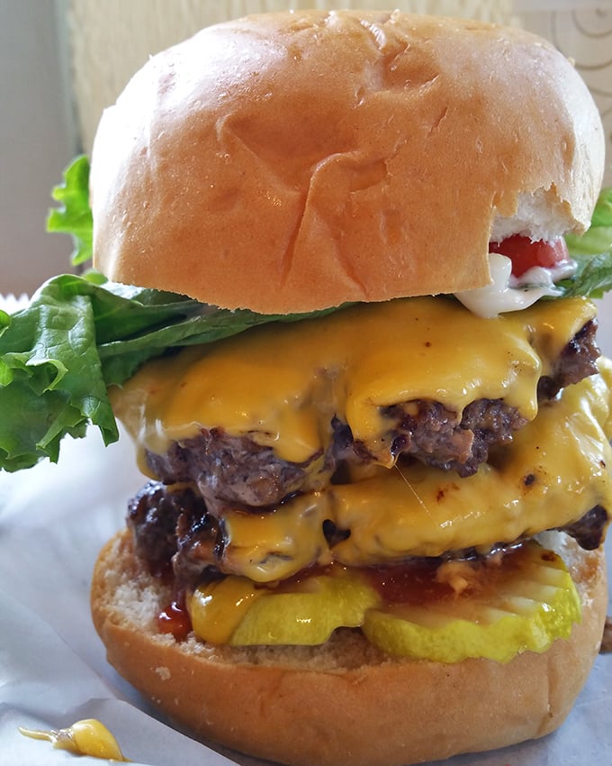 Behold the tower of power. This double cheeseburger doesn't just satisfy hunger—it creates memories with each perfectly melted, gloriously messy bite.