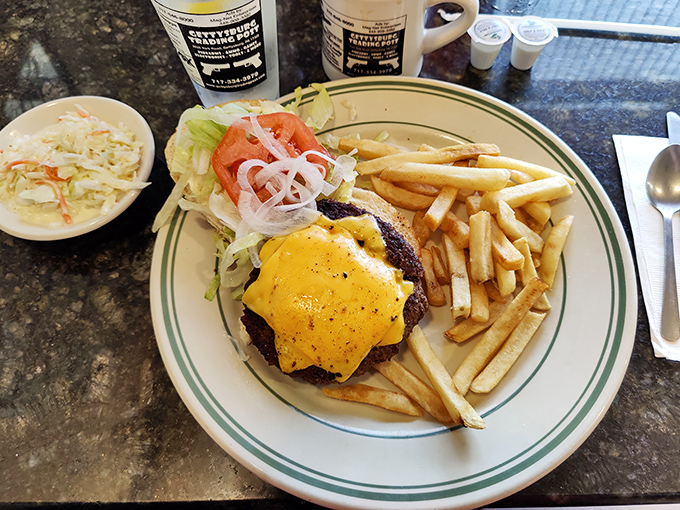This isn't just a cheeseburger—it's edible architecture. The perfectly melted cheese cascades over a hand-formed patty while crispy fries stand at attention nearby.