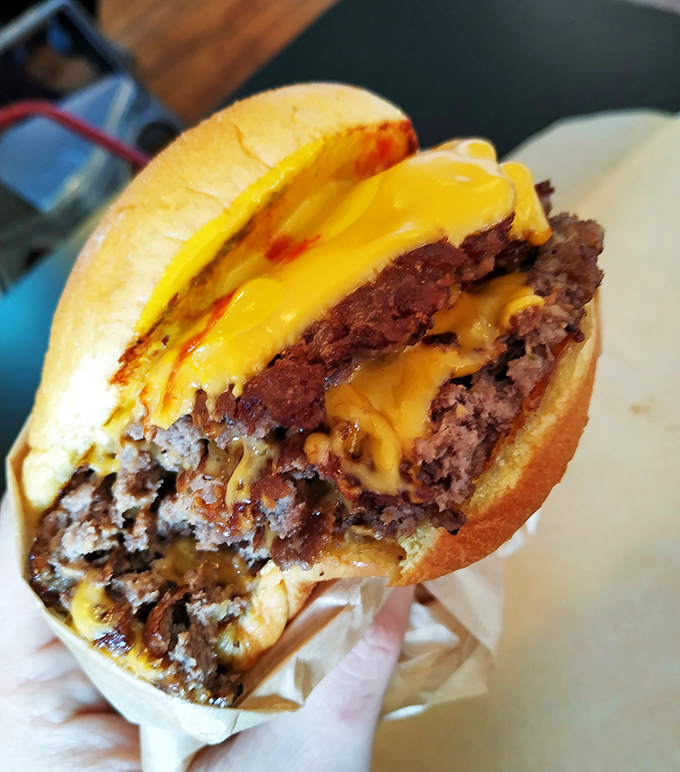 The money shot! Perfectly melted cheese cascading down hand-formed patties. This isn't a burger—it's edible artwork.