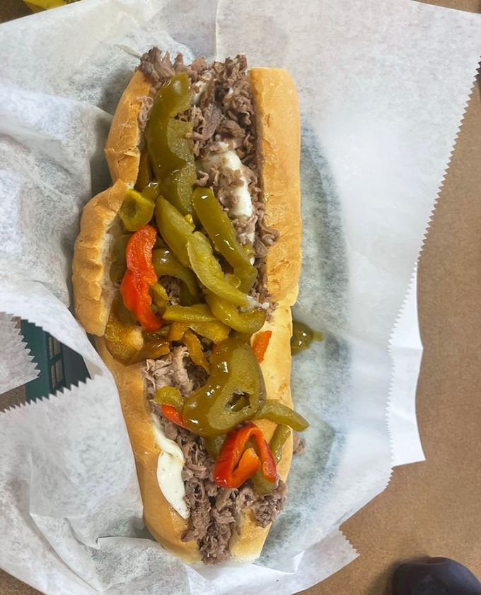 Behold the star of the show—thinly sliced beef nestled in a perfect roll, crowned with peppers that add both color and kick.
