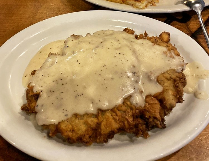 Behold the holy grail of Texas cuisine: chicken fried steak smothered in peppery cream gravy that cascades over the edges like a delicious waterfall.