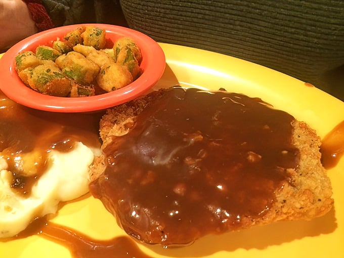 The legendary chicken fried steak in all its gravy-drenched glory. That golden crust shatters with each bite, revealing tender beef beneath – worth every mile of the drive.
