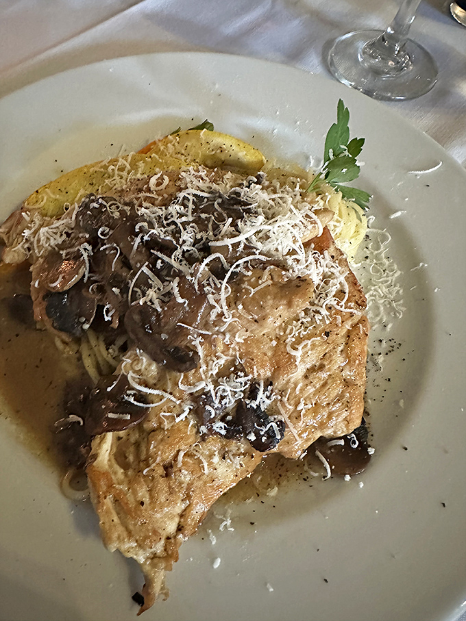 Chicken and mushrooms performing a delicious tango atop pasta. The shaved parmesan snowfall on top isn't just garnish—it's essential happiness.