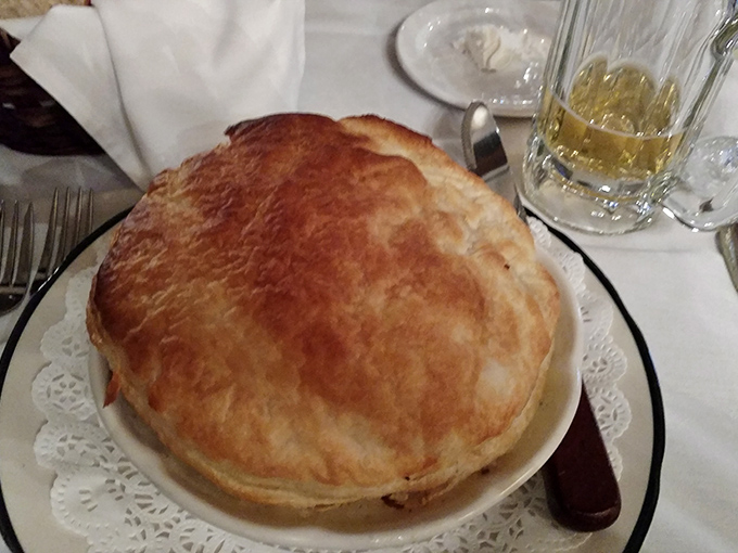 The chicken pot pie arrives like a golden-domed cathedral of comfort. Breaking through that flaky crust releases steam that smells like your grandmother's kitchen—if grandma was a classically trained chef.